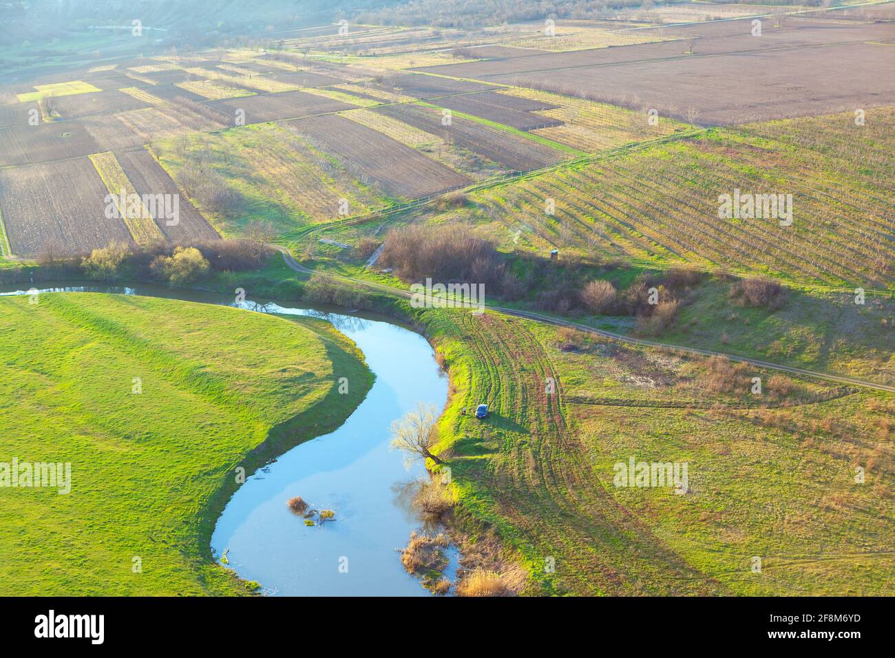 Top view of flowing river with fields and gardens . Spring rustic ...