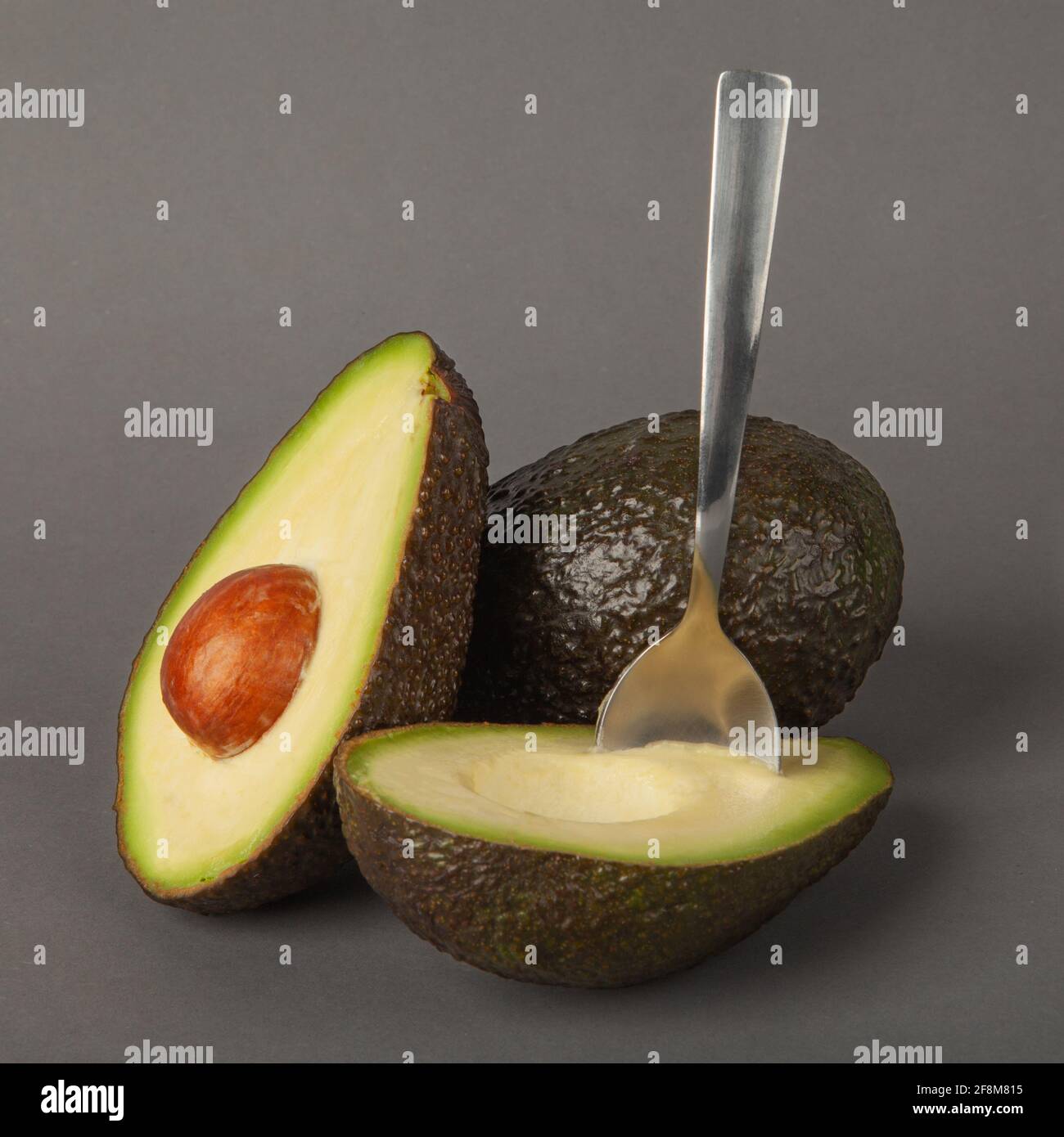 Two ripe avocado fruits lie on a gray background Stock Photo - Alamy