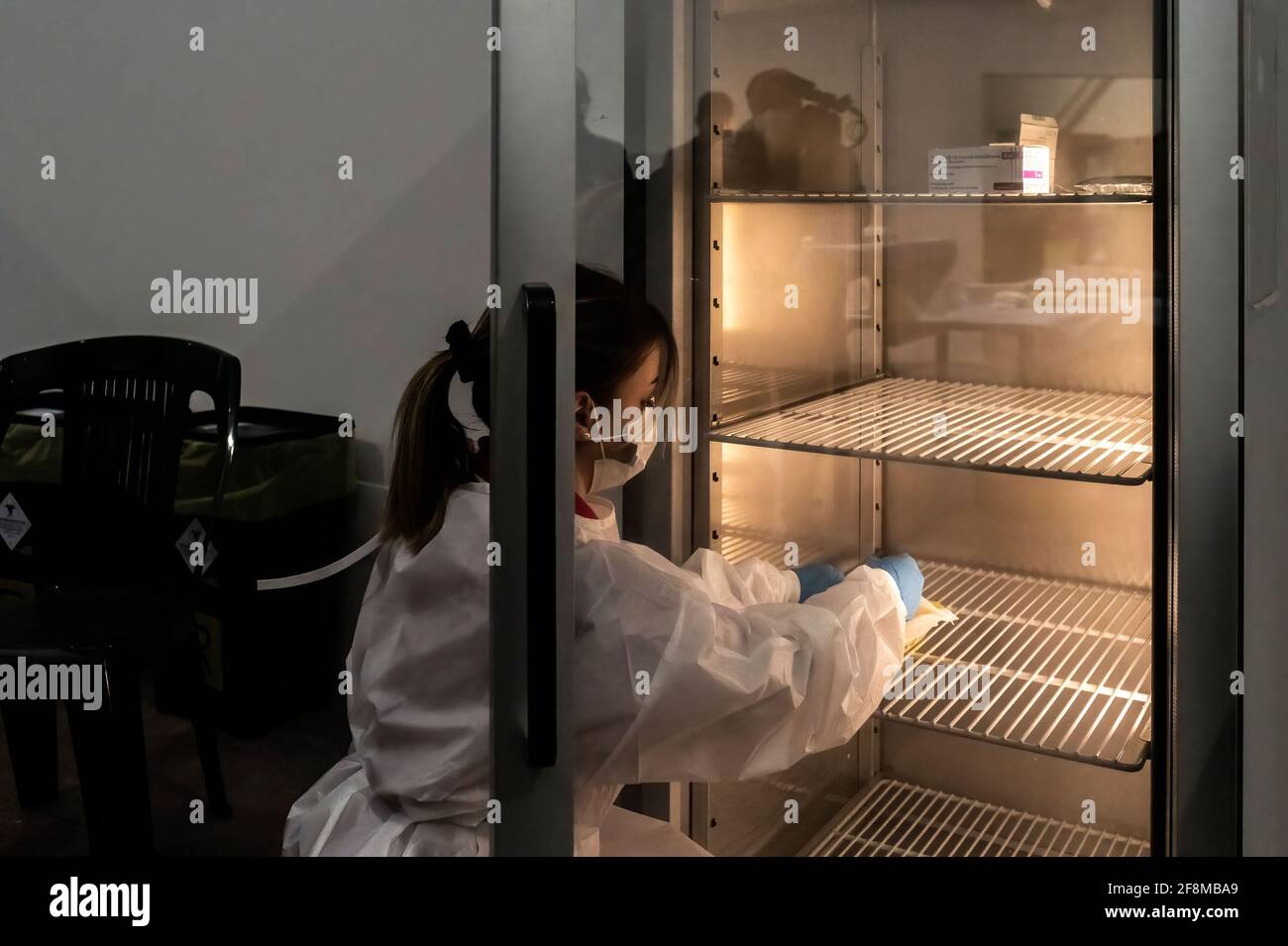 A sanitary worker seen cleaning the vaccine's storage fridge during the ...