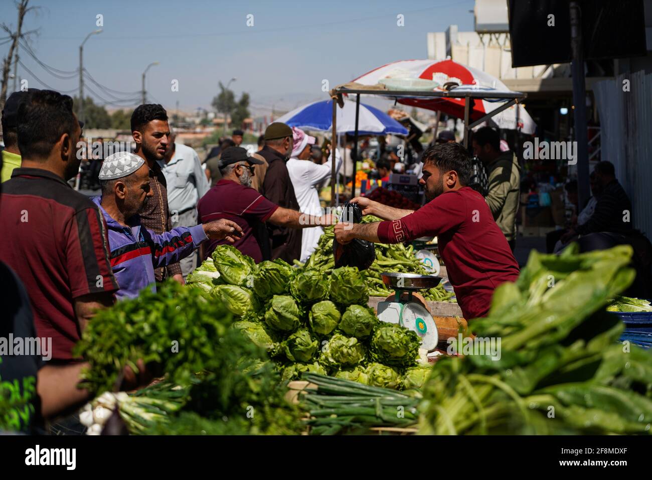 People buys vegetables from a seller near to Bab Al-Saray market during ...