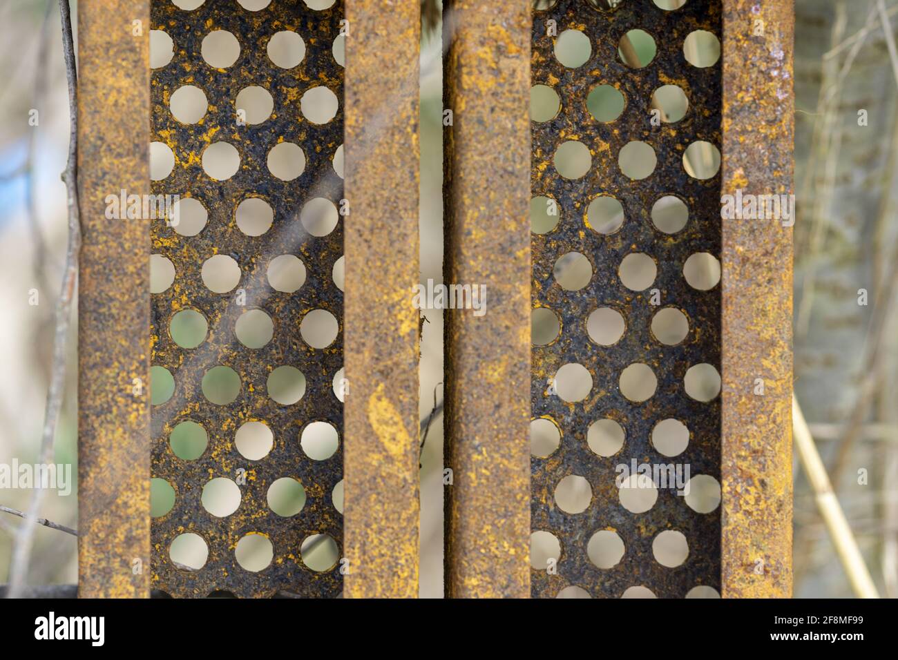 Closeup of two vertical rusted iron bars with holes in them Stock Photo ...