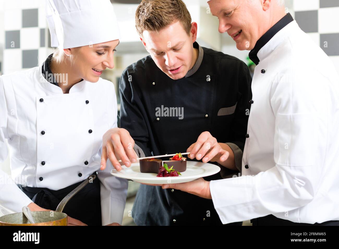 Chef team in restaurant kitchen with dessert working together Stock ...