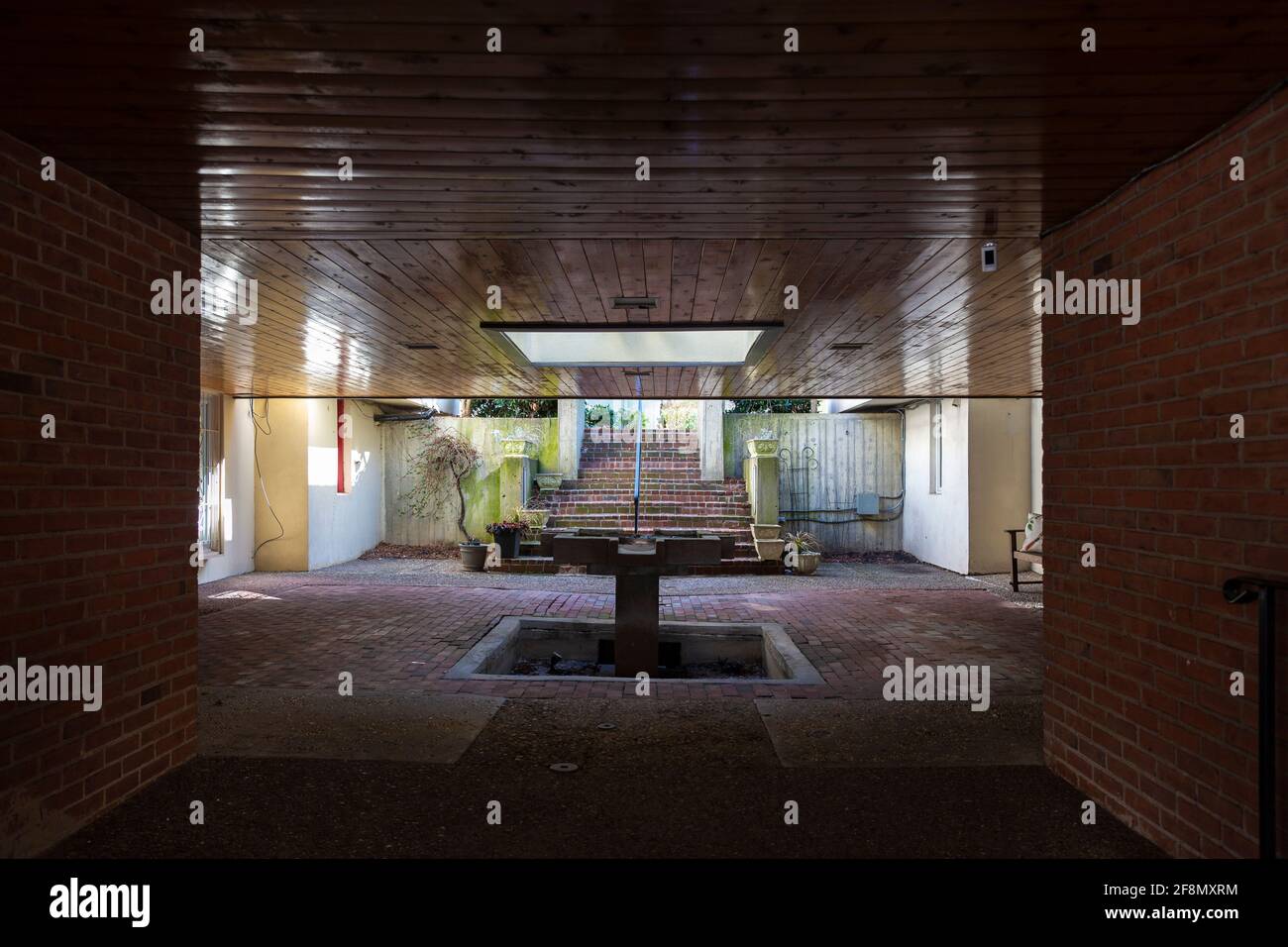 dry fountain in the middle of backyard with wooden roof and skylight ...