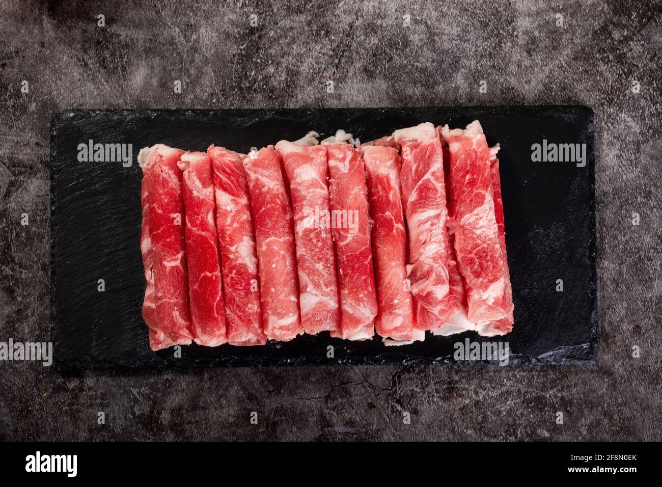 Top view of raw rolled mutton on a dark platter Stock Photo - Alamy