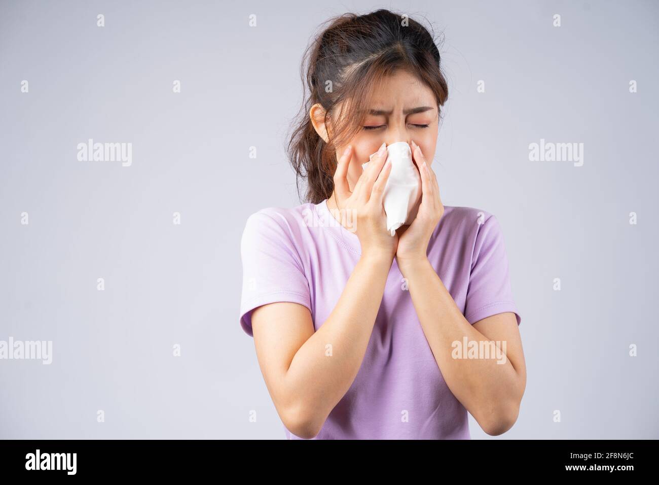 Young Asian woman is wiping her nose with a tissue Stock Photo - Alamy