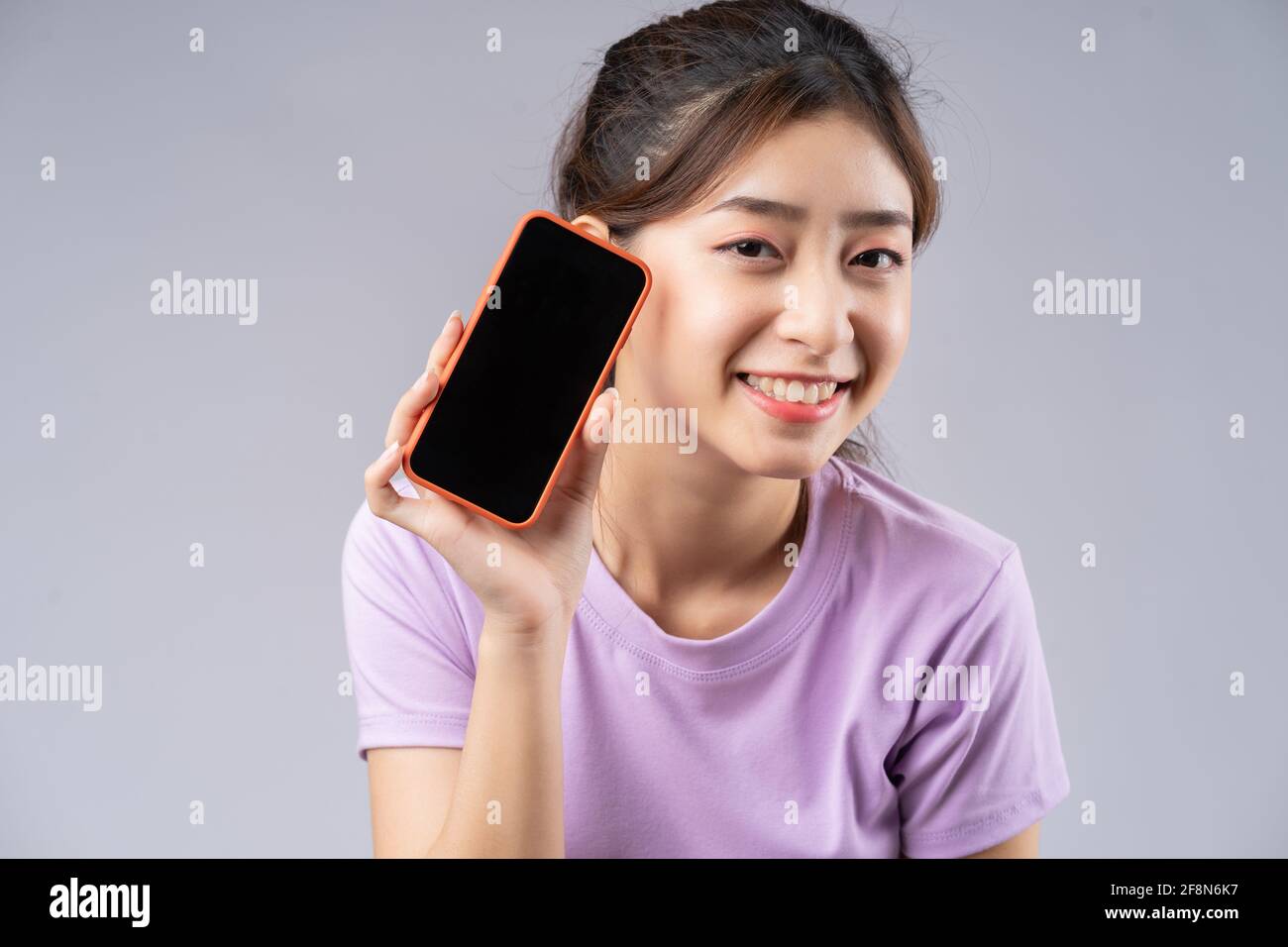Young Asian woman showing smartphone's blank screen Stock Photo - Alamy