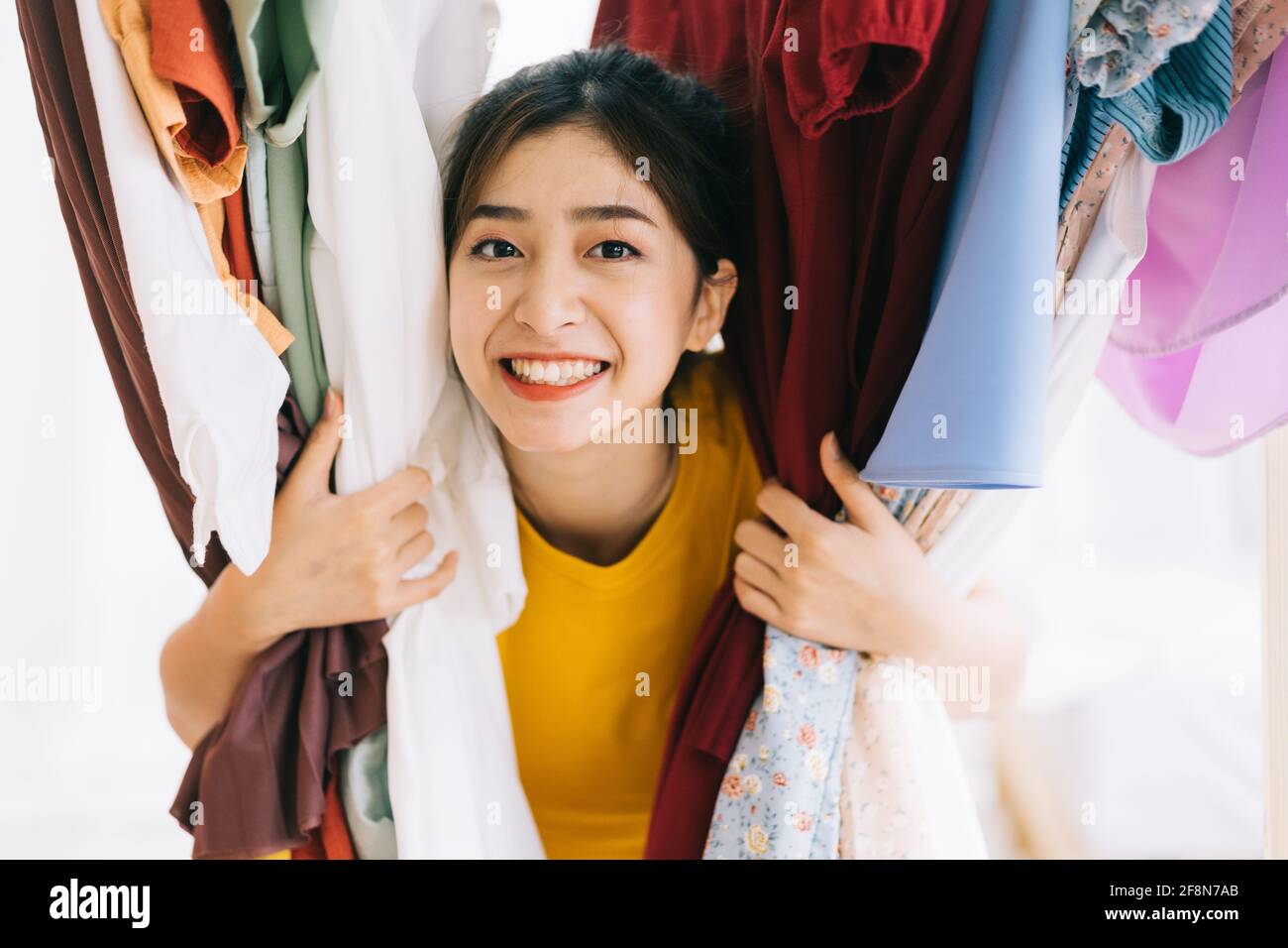 Asian girl stuck in her mess of clothes Stock Photo - Alamy