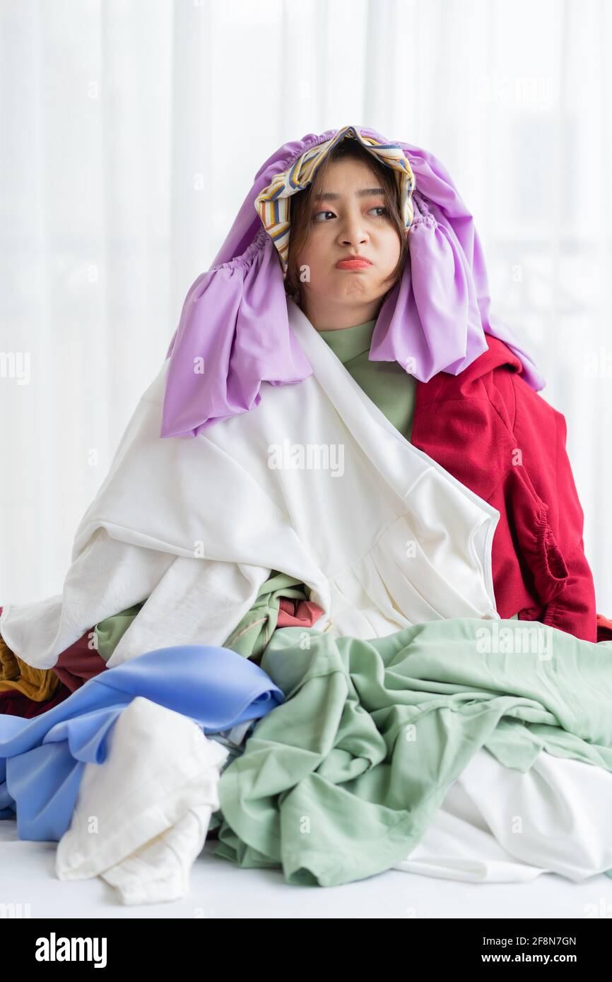 Asian girl stuck in her mess of clothes Stock Photo - Alamy