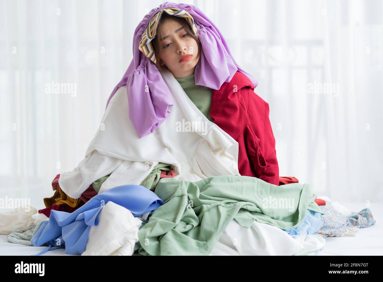 Asian girl stuck in her mess of clothes Stock Photo - Alamy