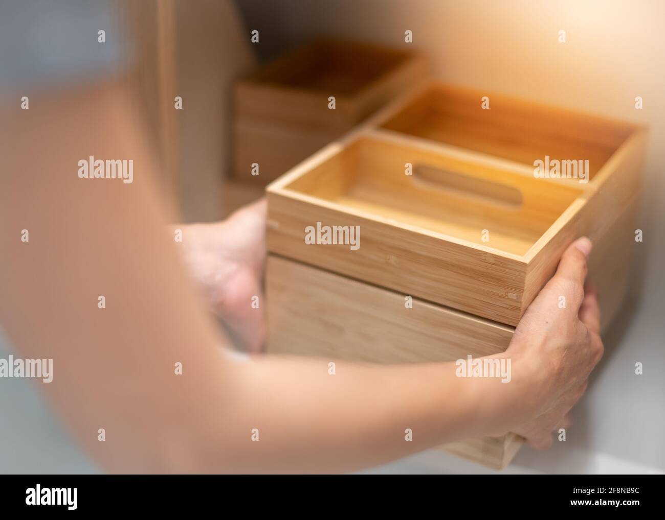 Female hand holding the wood box for arrange on the shelf for ...