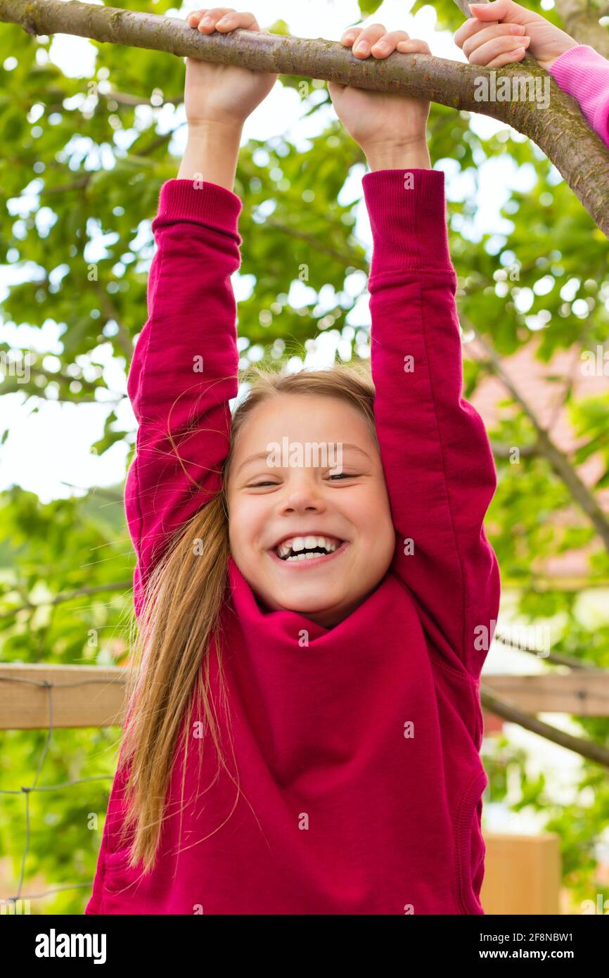 Happy child playing in the garden hanging on the tree Stock Photo - Alamy