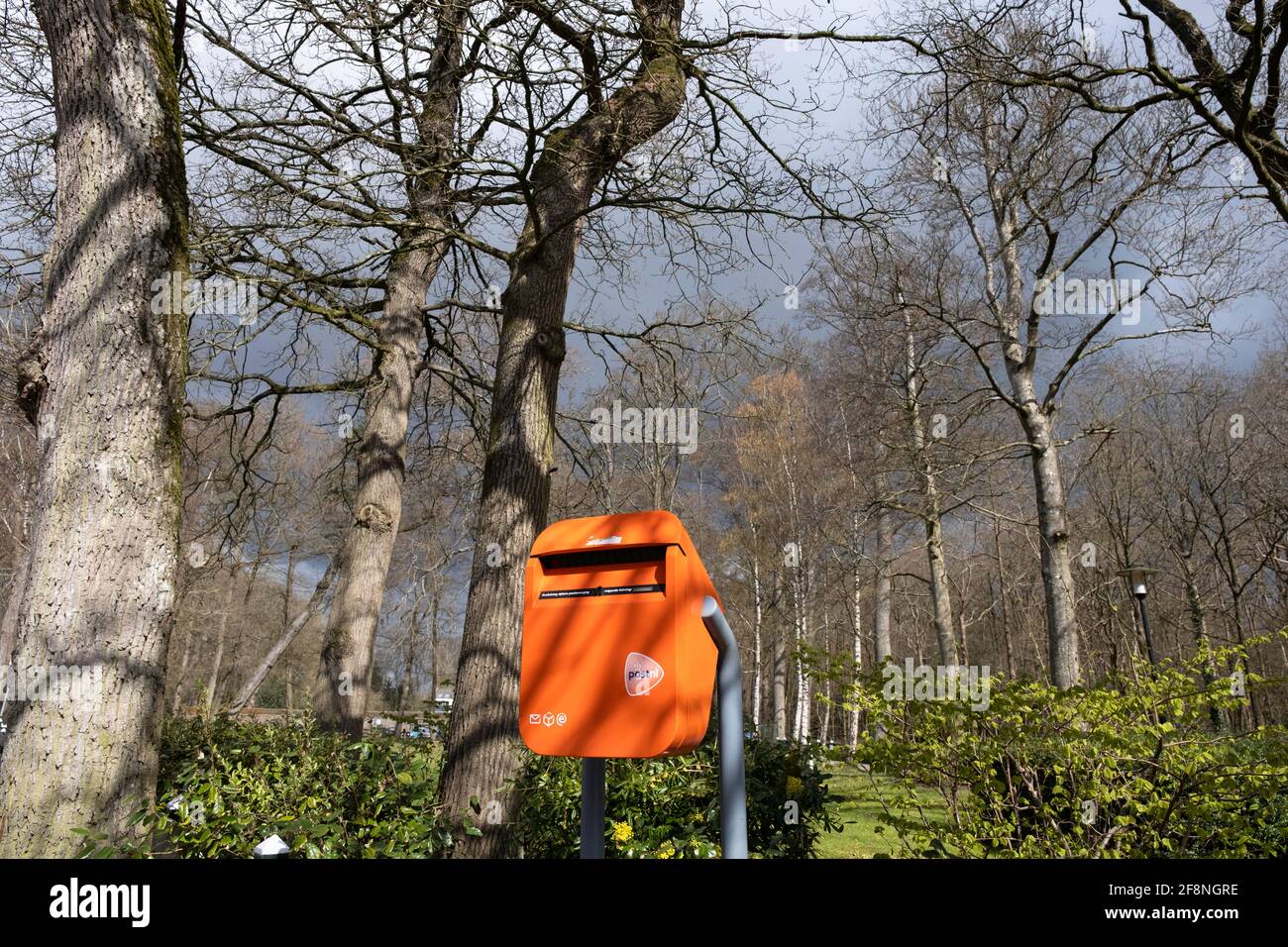 Typical Dutch orange letterbox with PostNL logo, which is outside in a ...