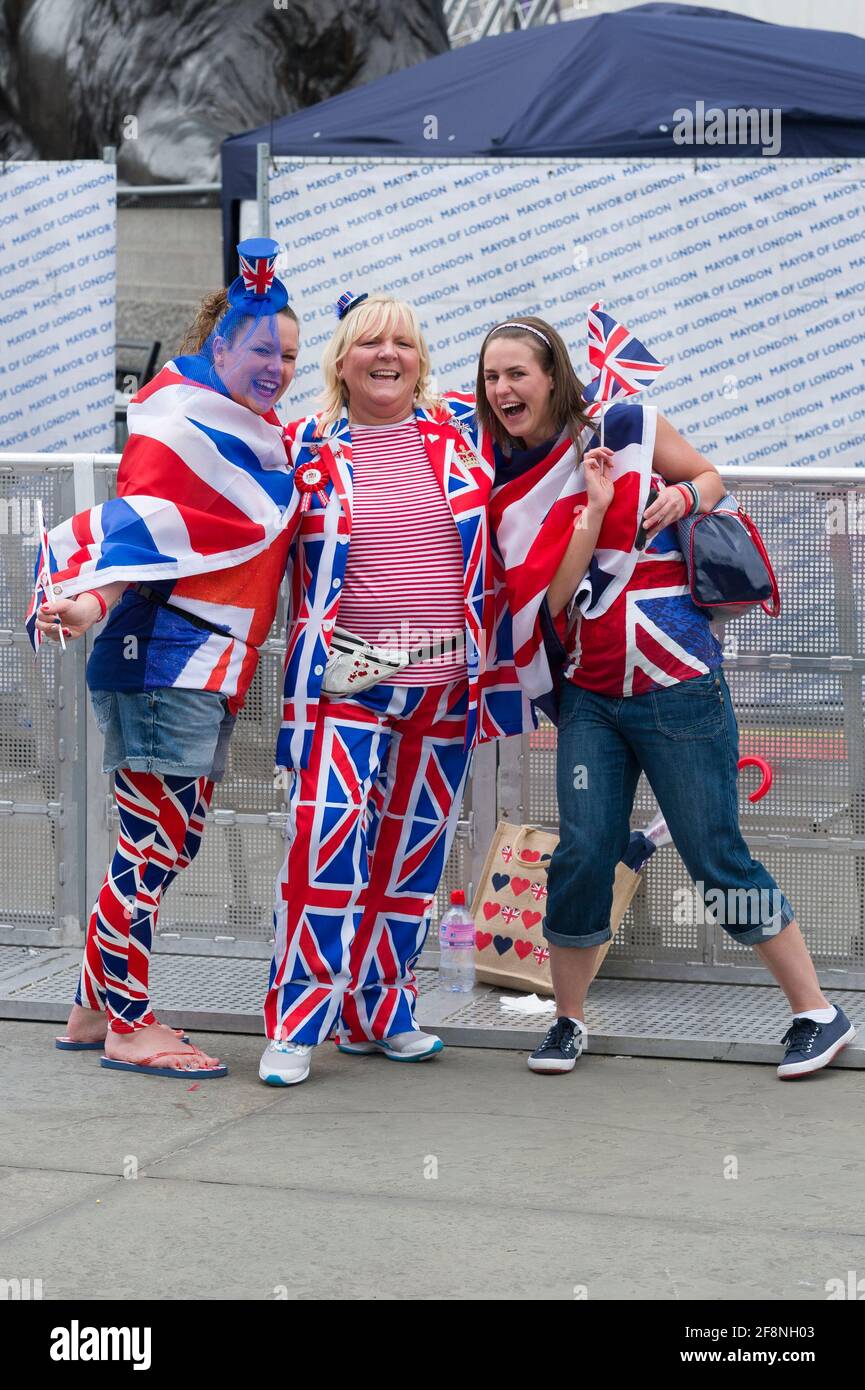 Three women wearing Union Jack who are part of a large crowd of people ...