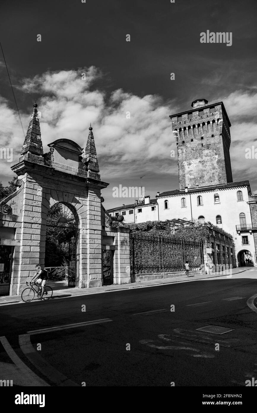 Grayscale shot of the tower of Porta Castello with a park and buildings ...