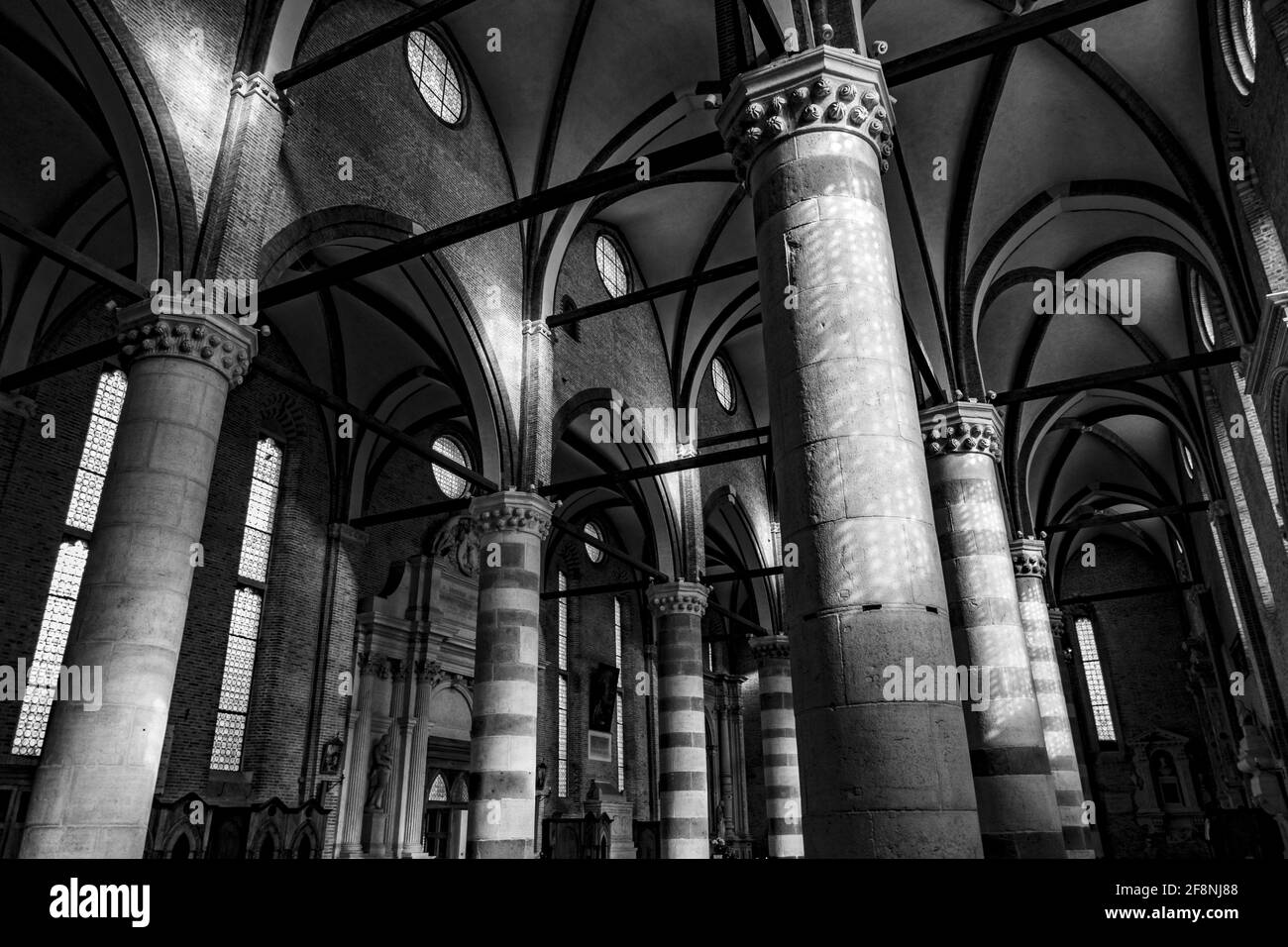 Grayscale shot of an interior of a church with arches and patterned ...
