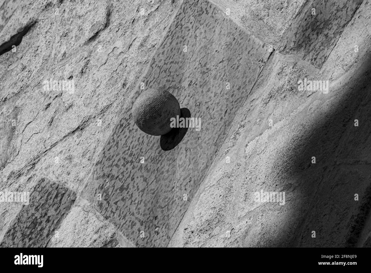 Grayscale shot of a round-shaped stone isolated on the stone patterned ...
