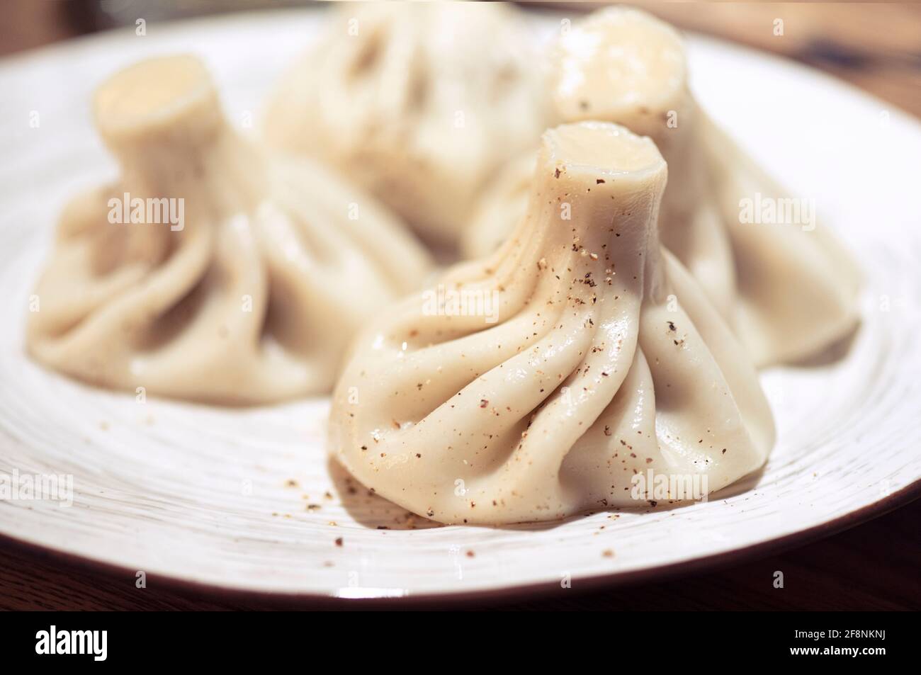 Some homemade boiled khinkali with pepper on ceramic plate, khinkali is ...