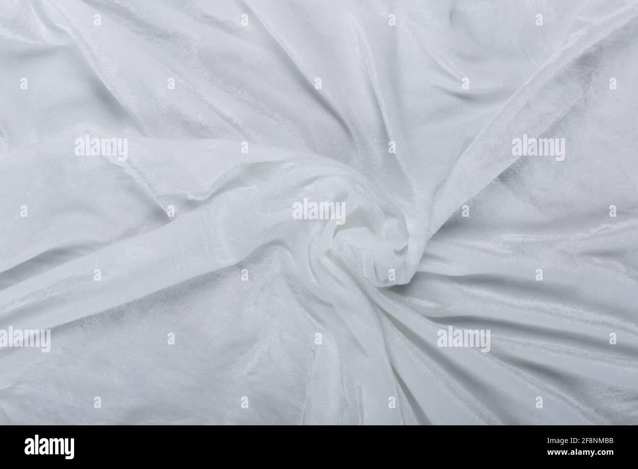 Colored white textile satin fabric folded in folds and waves with ...