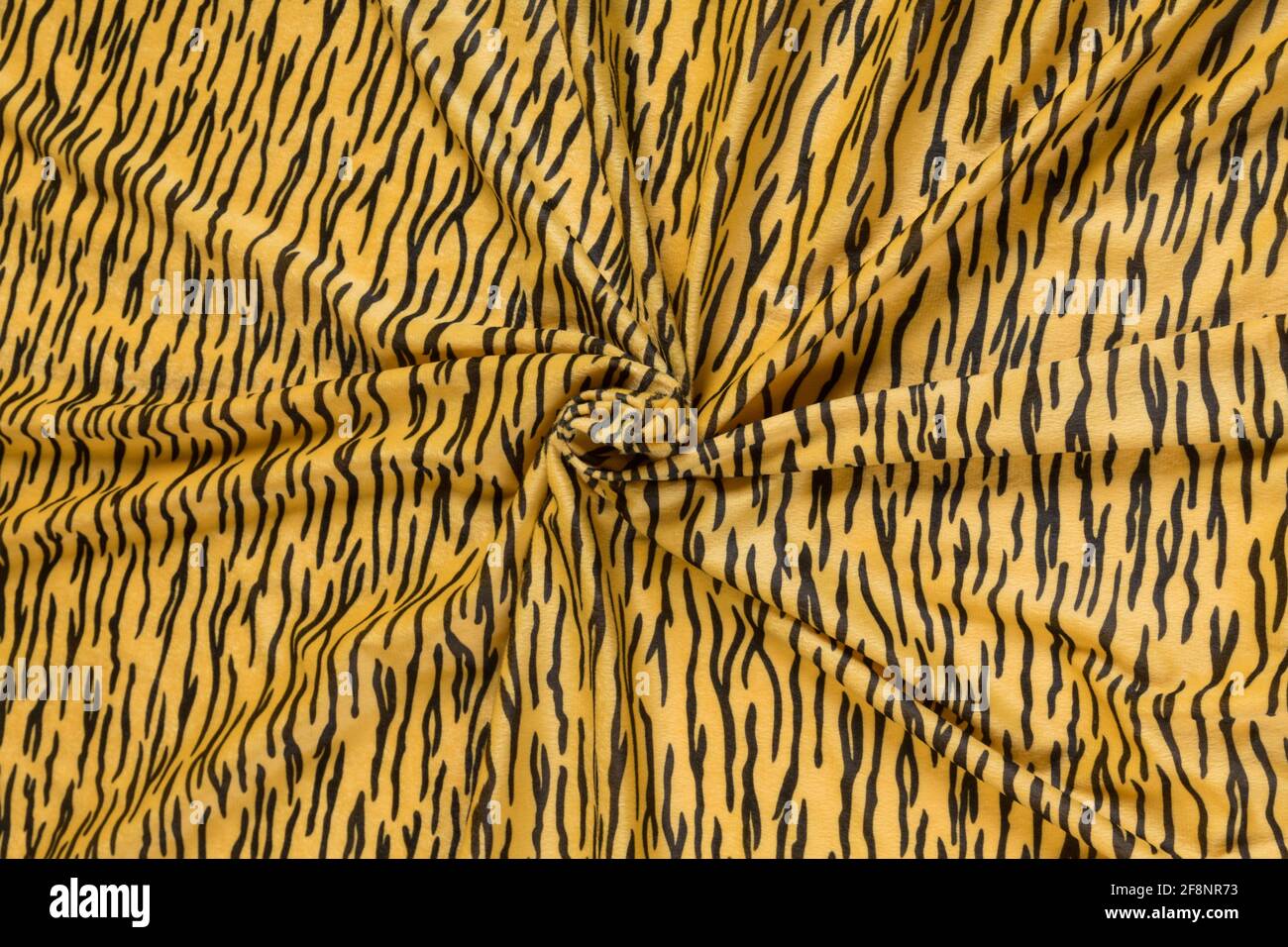 Colored yellow textile satin fabric folded in folds and waves with ...