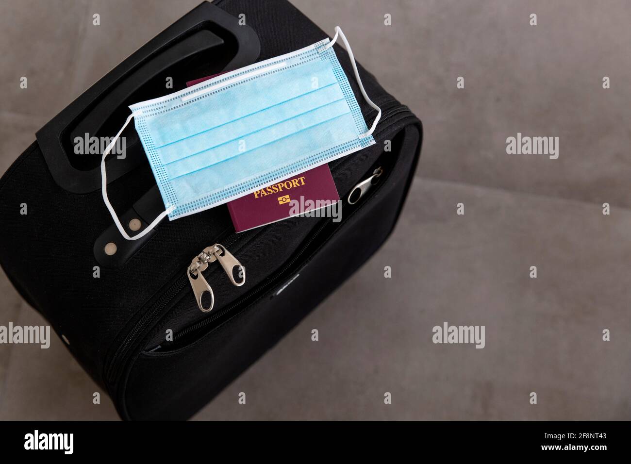 Coronavirus travel. Suitcase with a protective face mask and passport ...