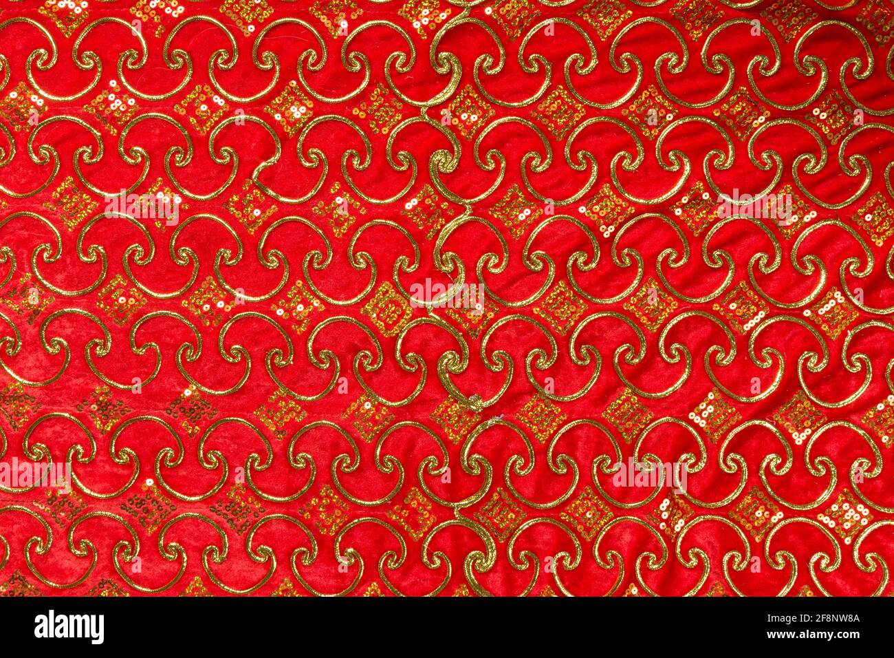Colored red textile satin fabric folded in folds and waves with ...