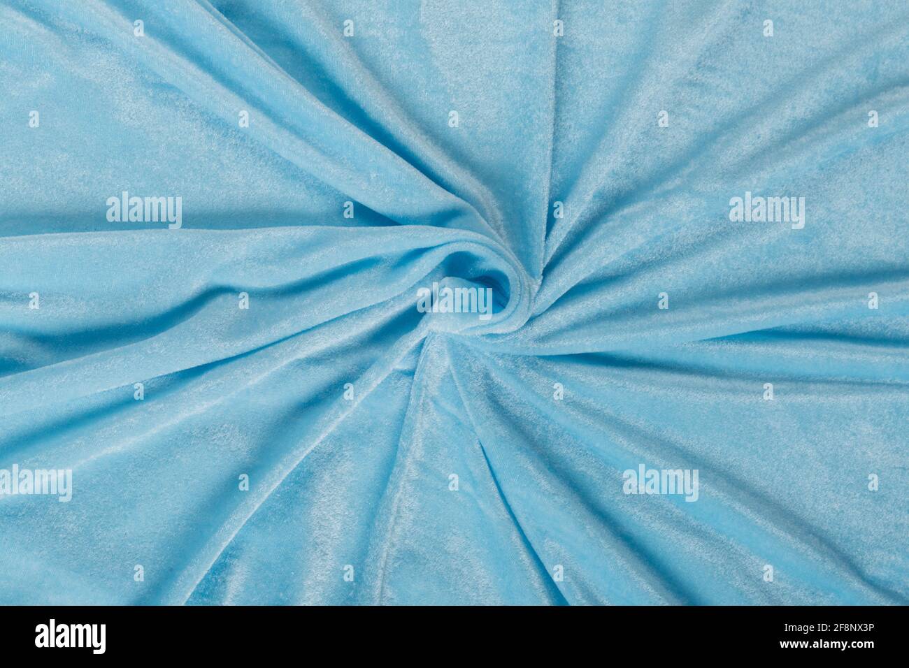 Colored blue textile satin fabric folded in folds and waves with ...