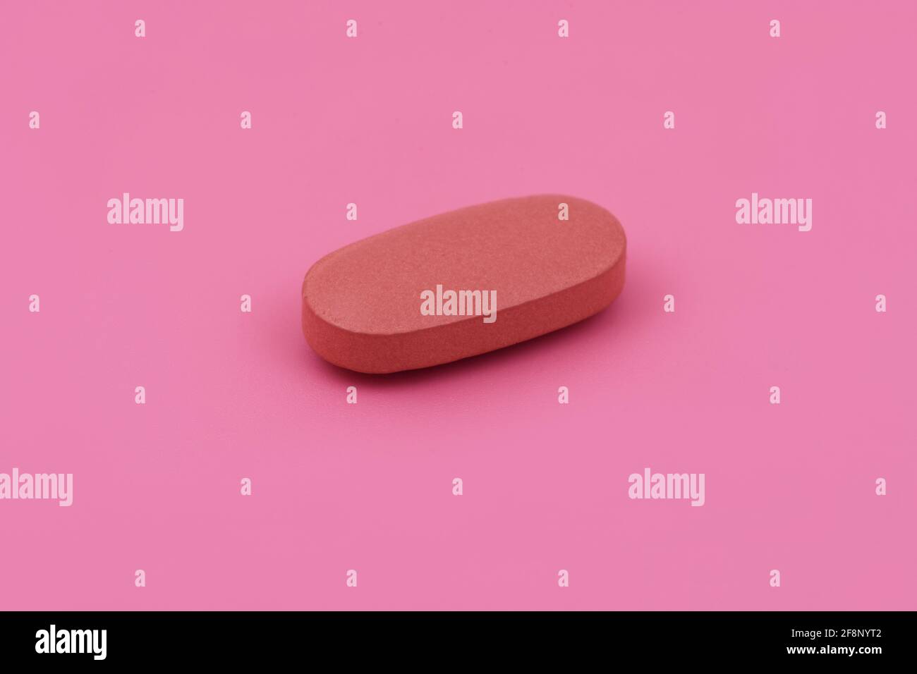Oval shape Pharmaceutical medicine tablet on pink background, Flat lay ...