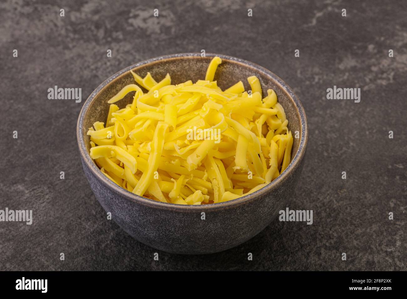Shredded yellow cheese in the bowl for cooking Stock Photo - Alamy