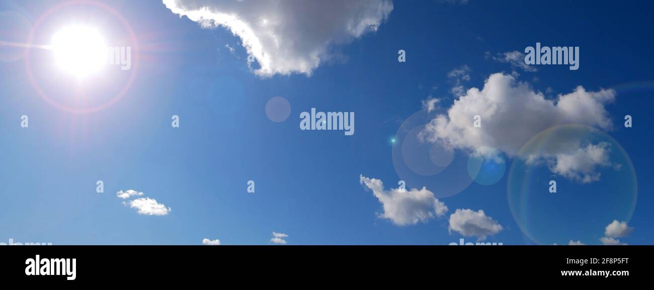 Panoramic photo of the sun against a blue sky with white clouds. Sun ...