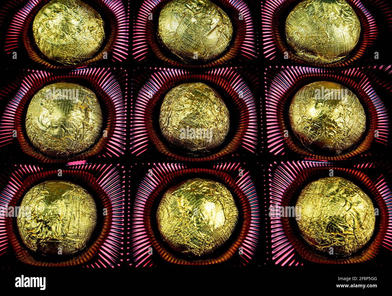 A box of chocolates in a golden foil wrapper. Sweets in shiny foil ...