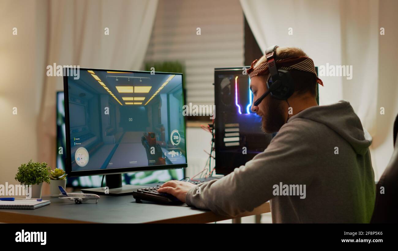 Cyber sport gamer wearing headphones playing first person shooter ...
