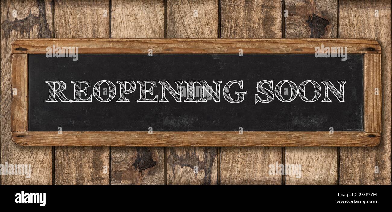 Chalkboard on rustic wooden background. Reopening soon text Stock Photo ...