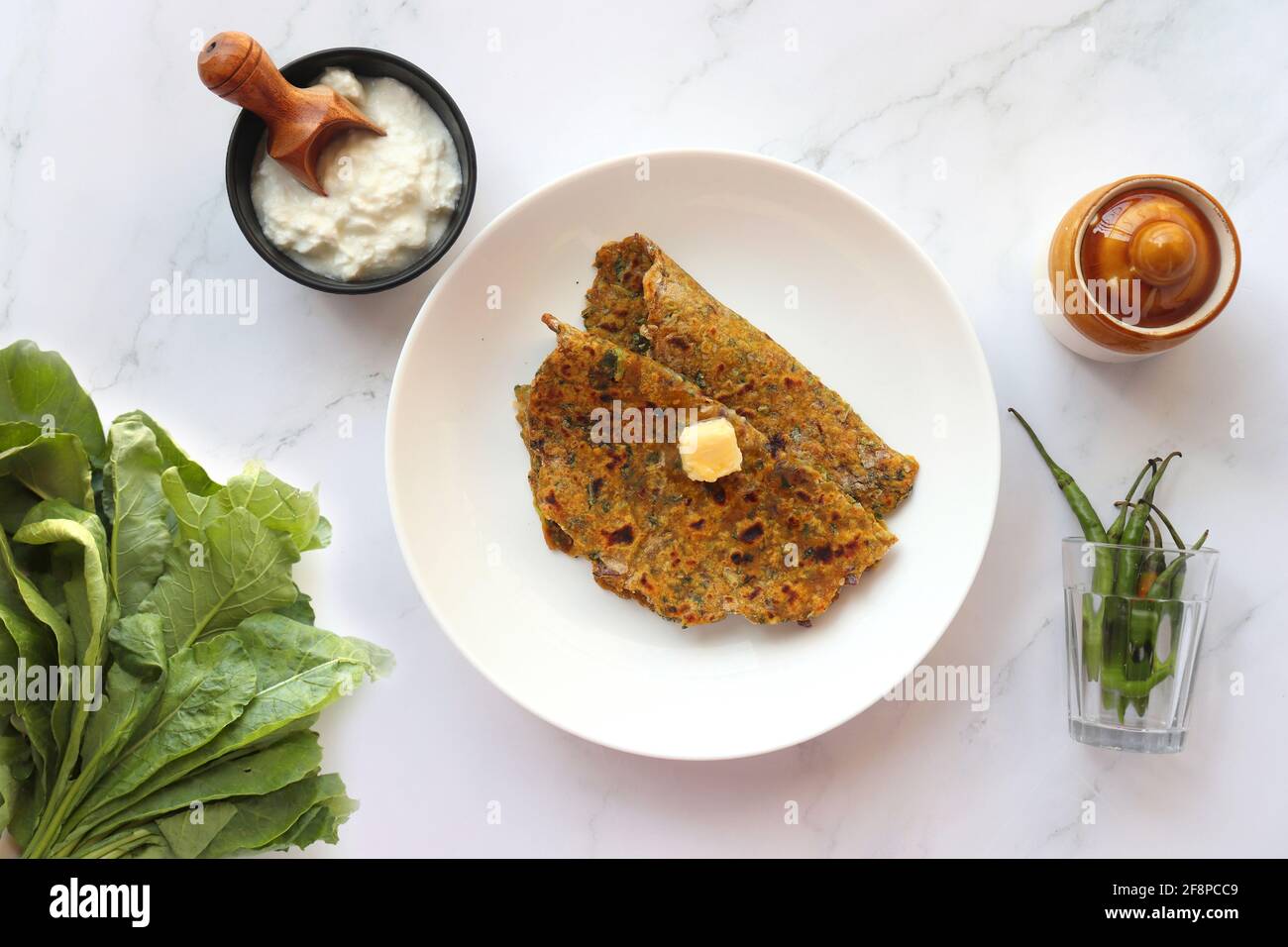 Radish or Mooli masala Paratha served on a white plate with butter ...