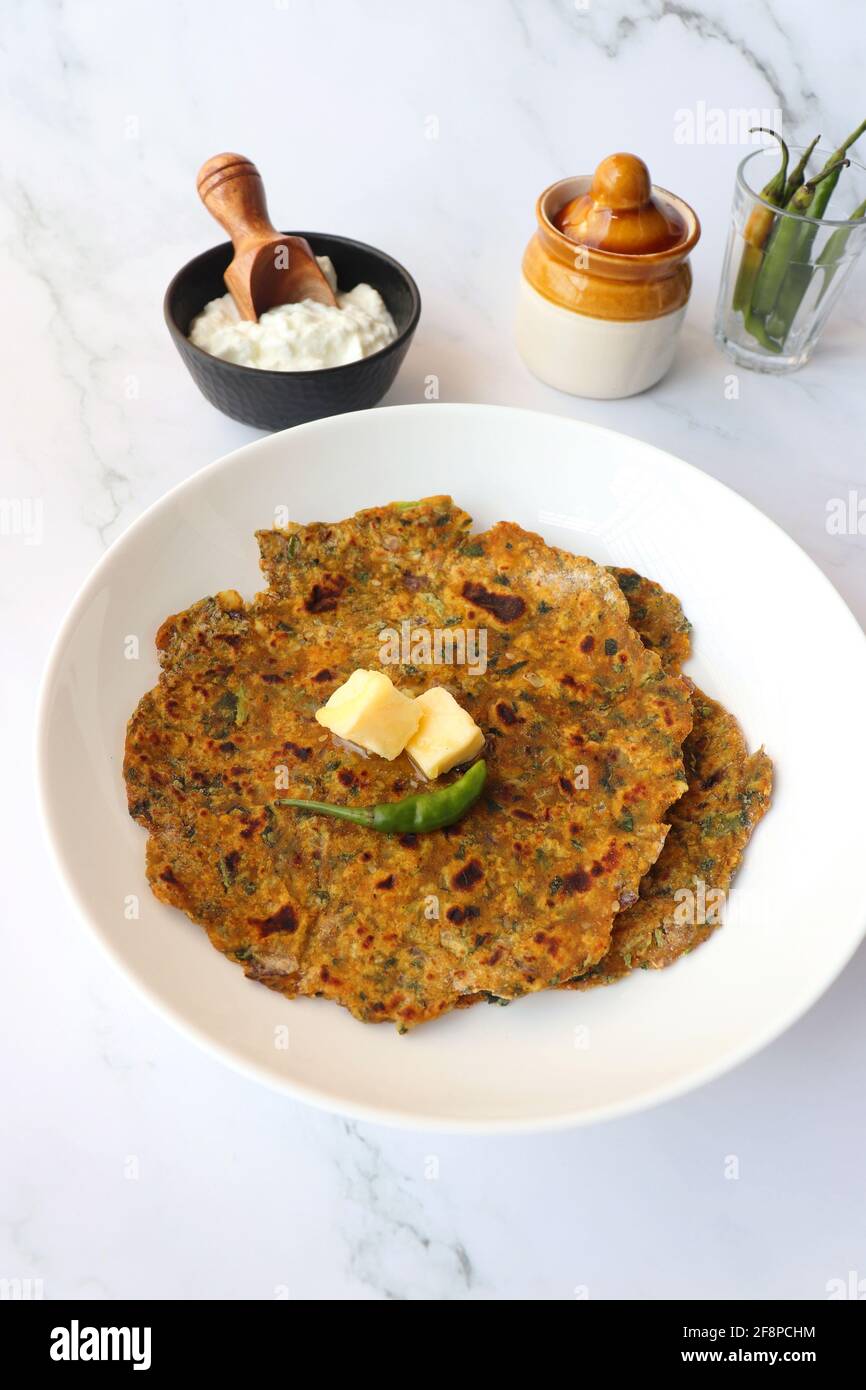 Radish or Mooli masala Paratha served on a white plate with butter ...