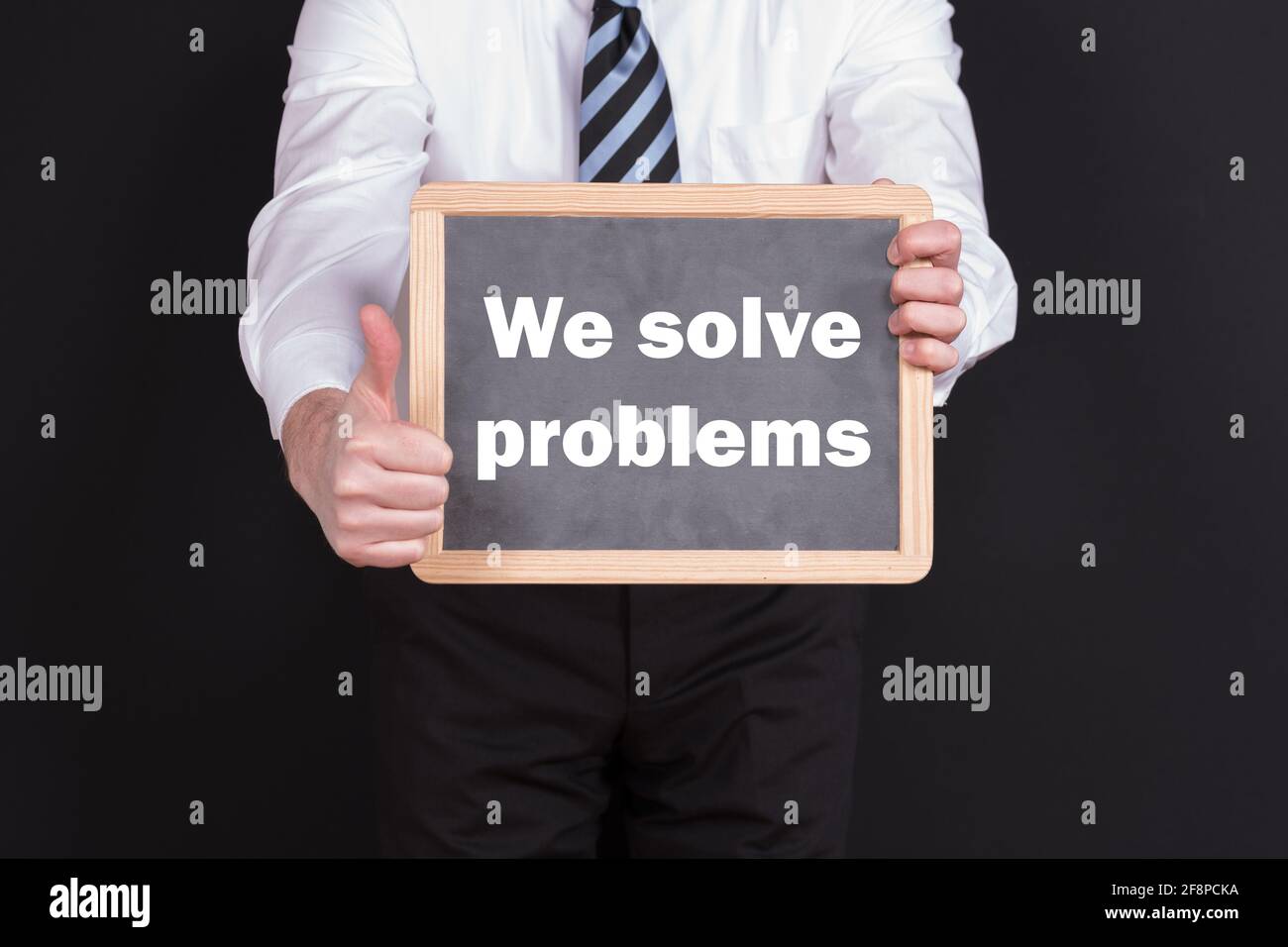 Office worker holding a blackboard with text: "We solve problems Stock ...