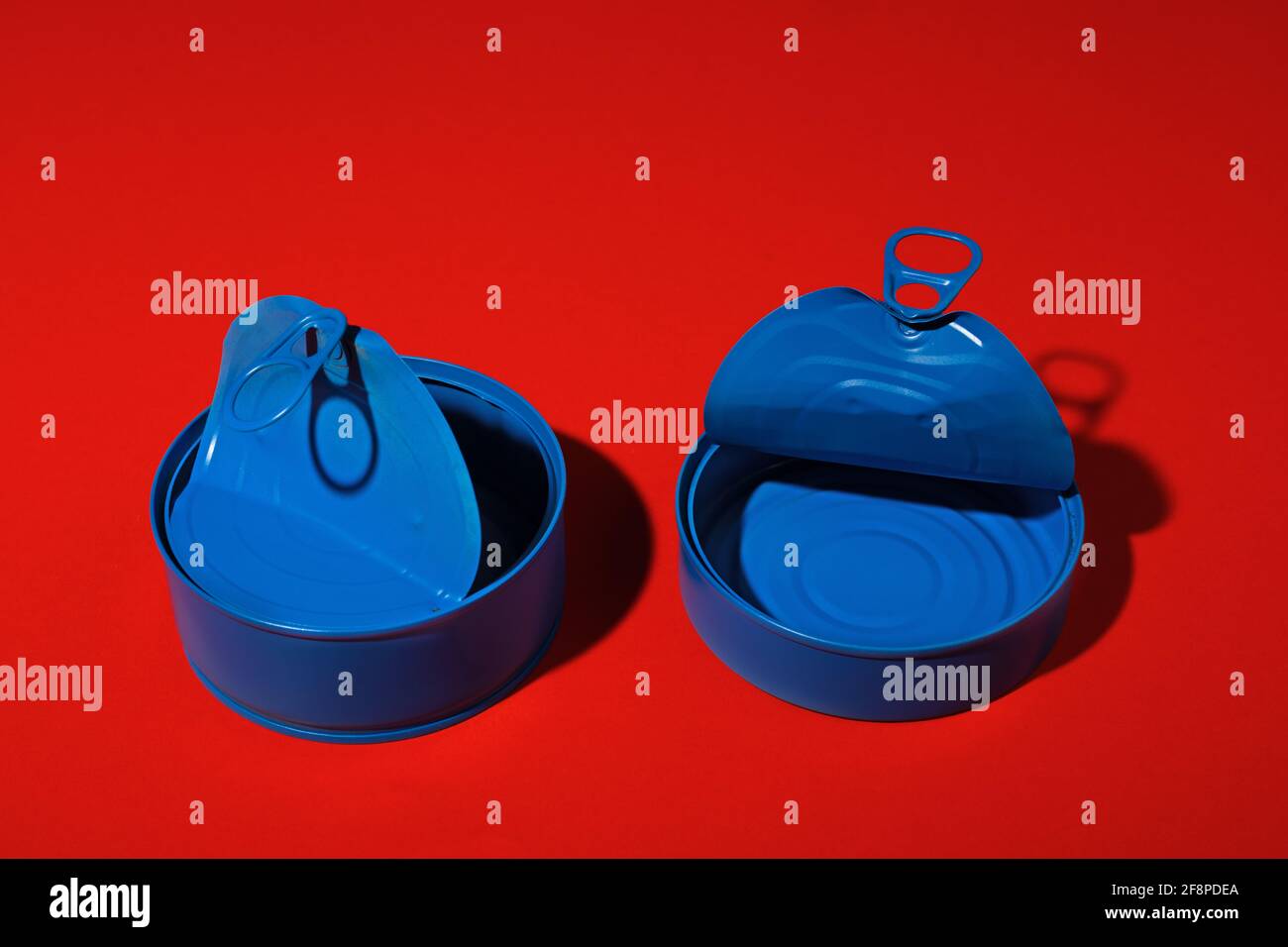 Blue tin can on dark red background Stock Photo - Alamy