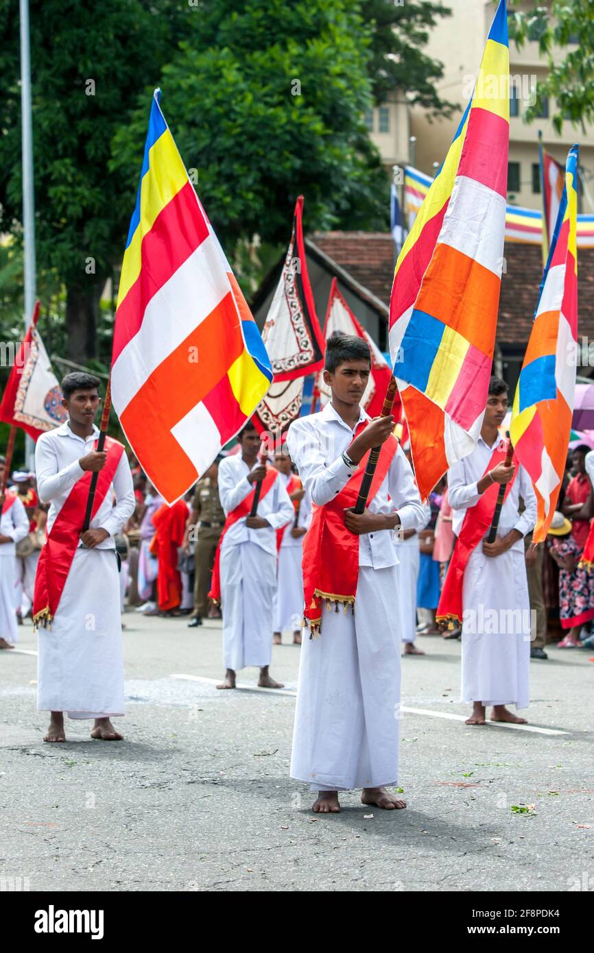 Buddhist Flag Bearers parade along a street in Kandy, Sri Lanka during ...
