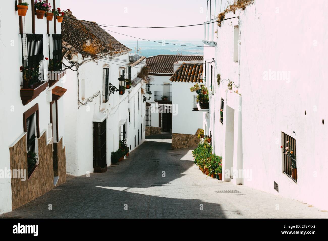 Narrow asphalt road with white buildings in Medina-Sidonia, Spanish ...