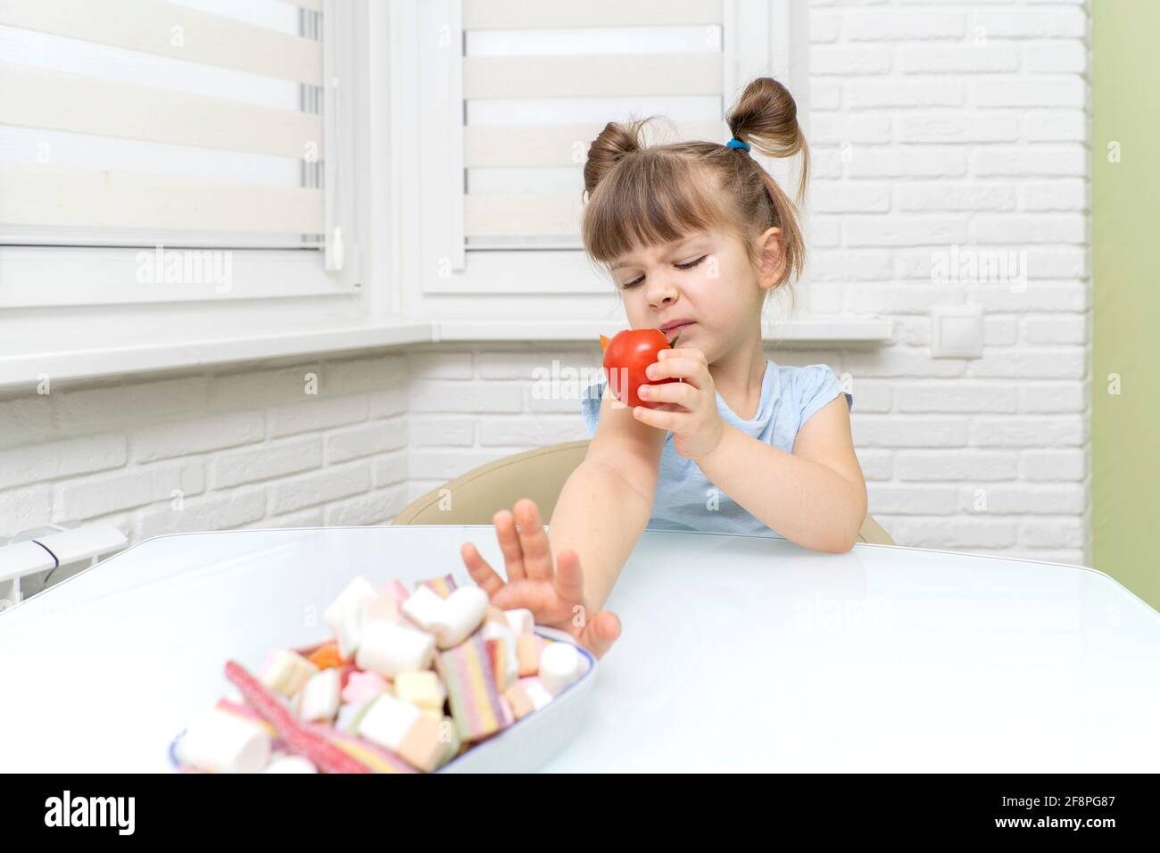 the little girl doesn't like the tomato, she reaches for a plate of ...