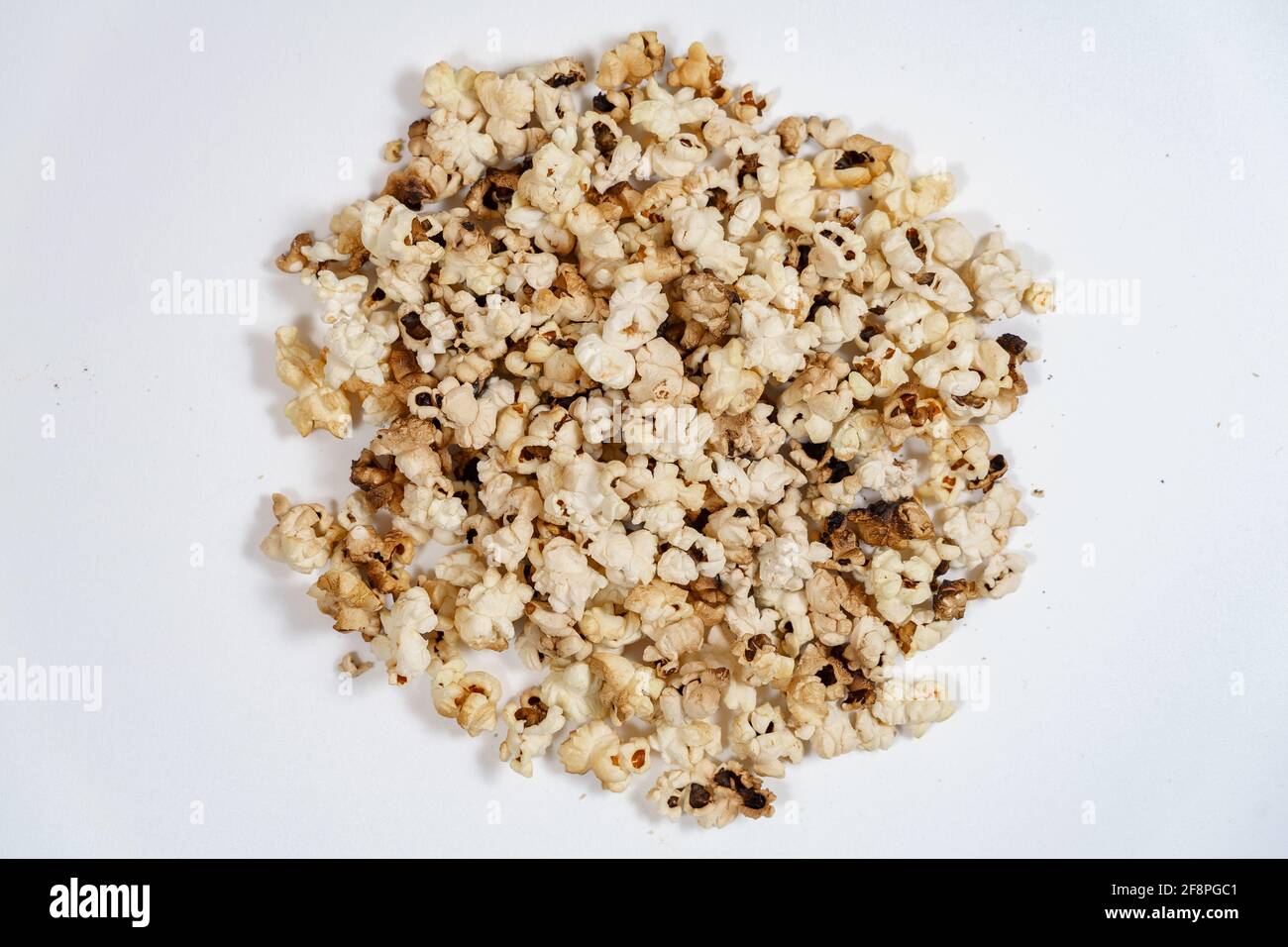 spoiled burnt popcorn grains on white background Stock Photo - Alamy