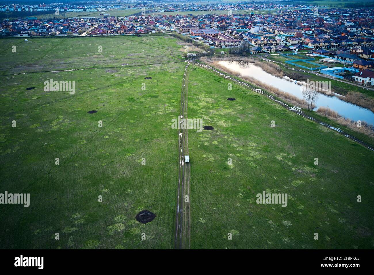A white and red truck rides along a highway through green fields. top ...