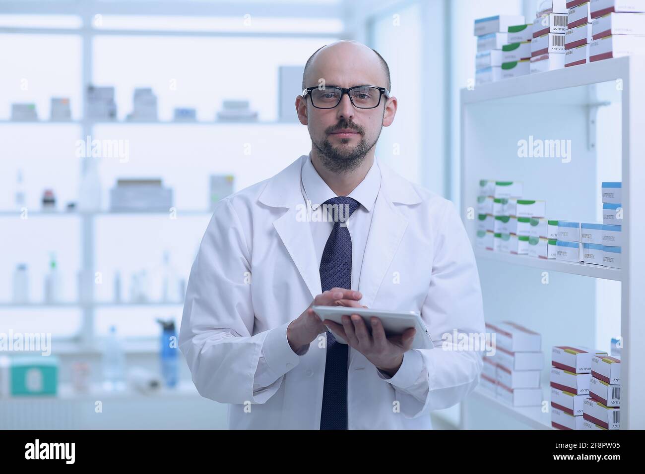 Pharmacist is working. Man wearing special medical uniform located in ...