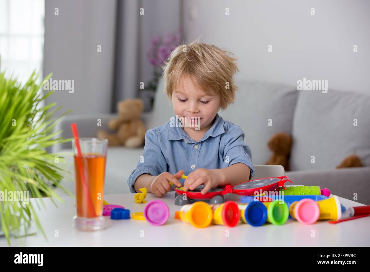 Cute blond child, sweet boy, playing with play doh modeline at home ...