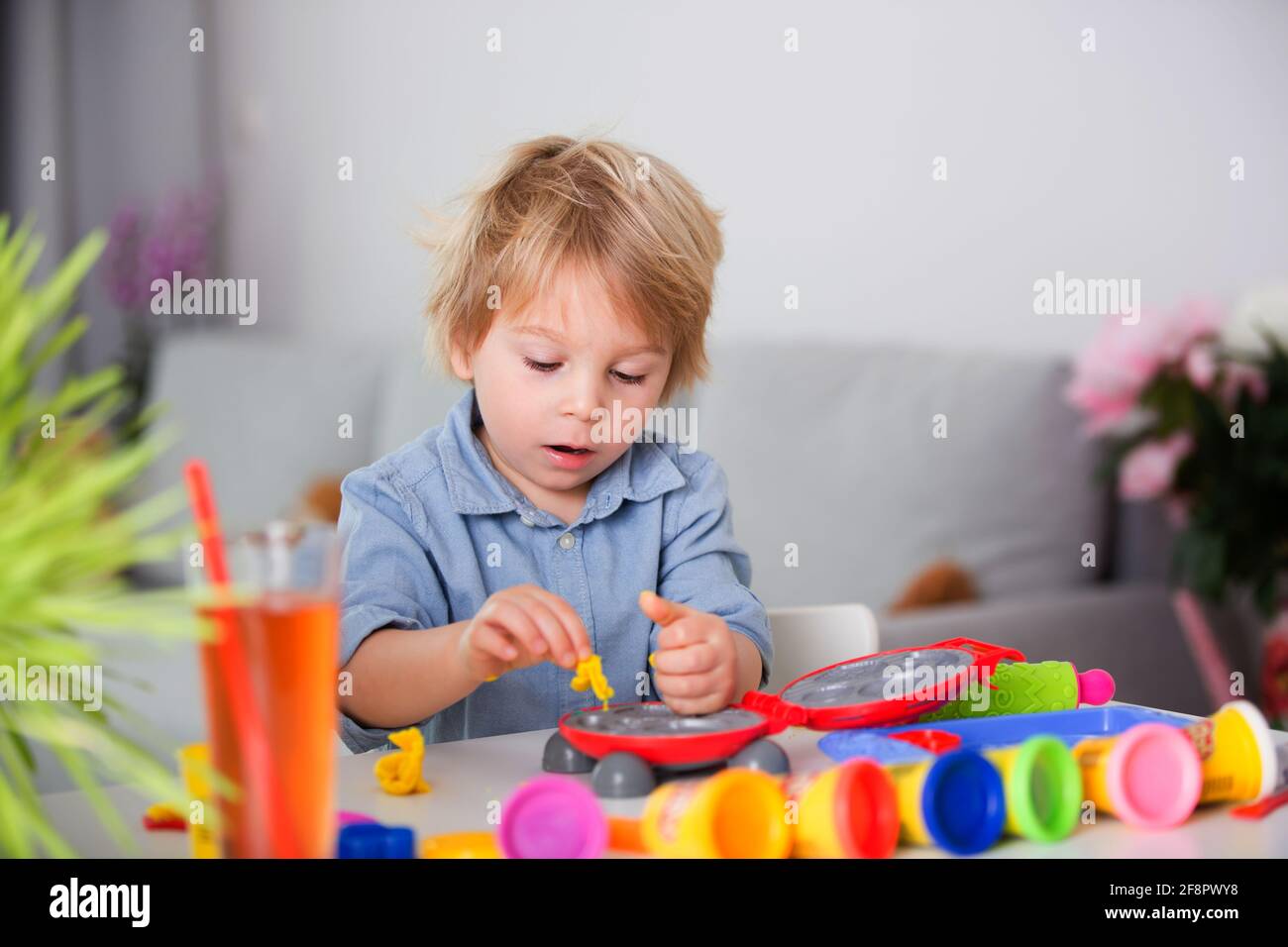 Cute blond child, sweet boy, playing with play doh modeline at home ...