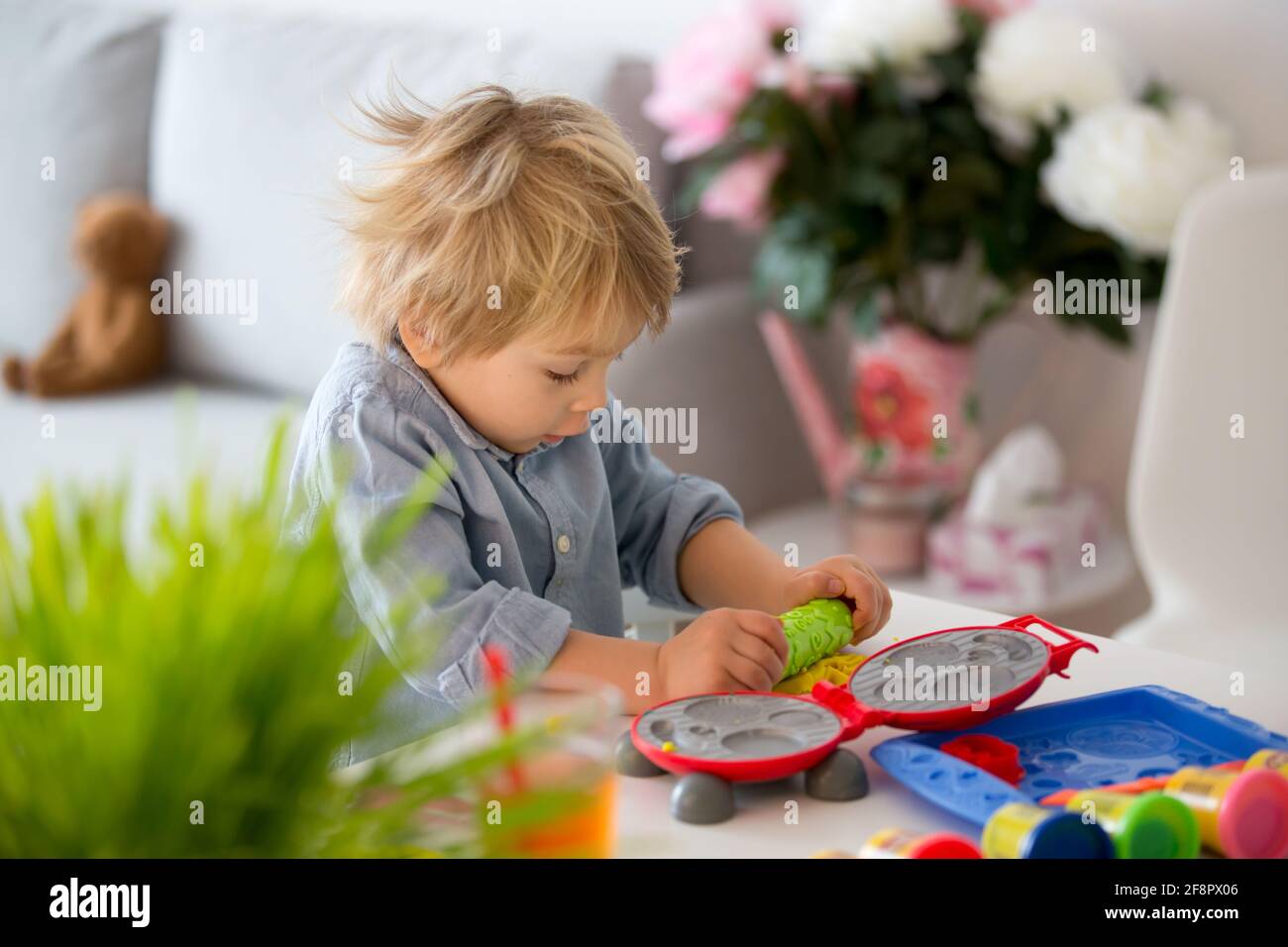 Cute blond child, sweet boy, playing with play doh modeline at home ...