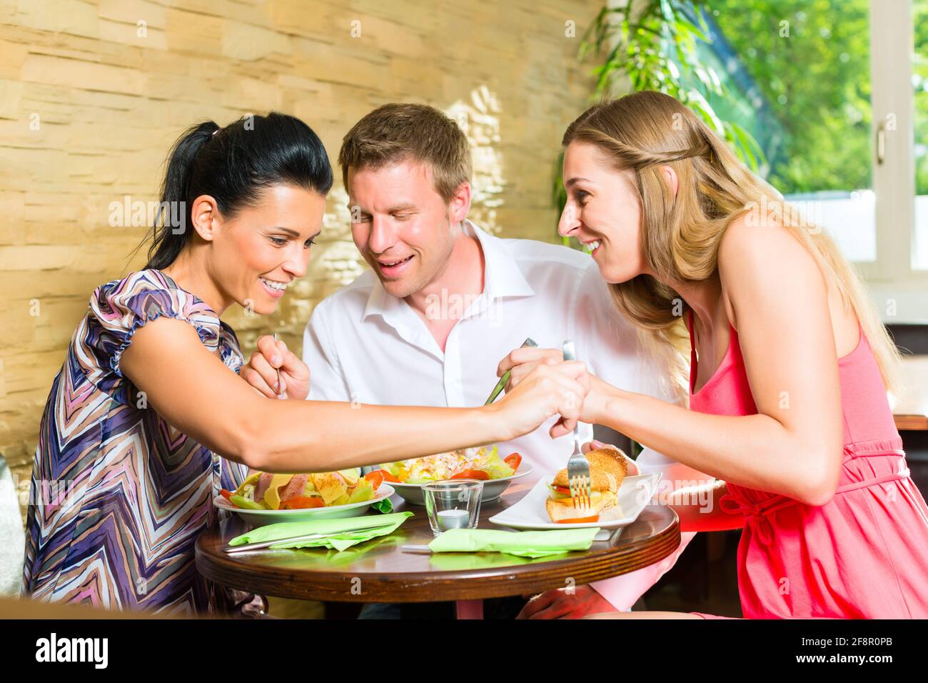 Man and women, perhaps colleagues or friends eating together healthy ...
