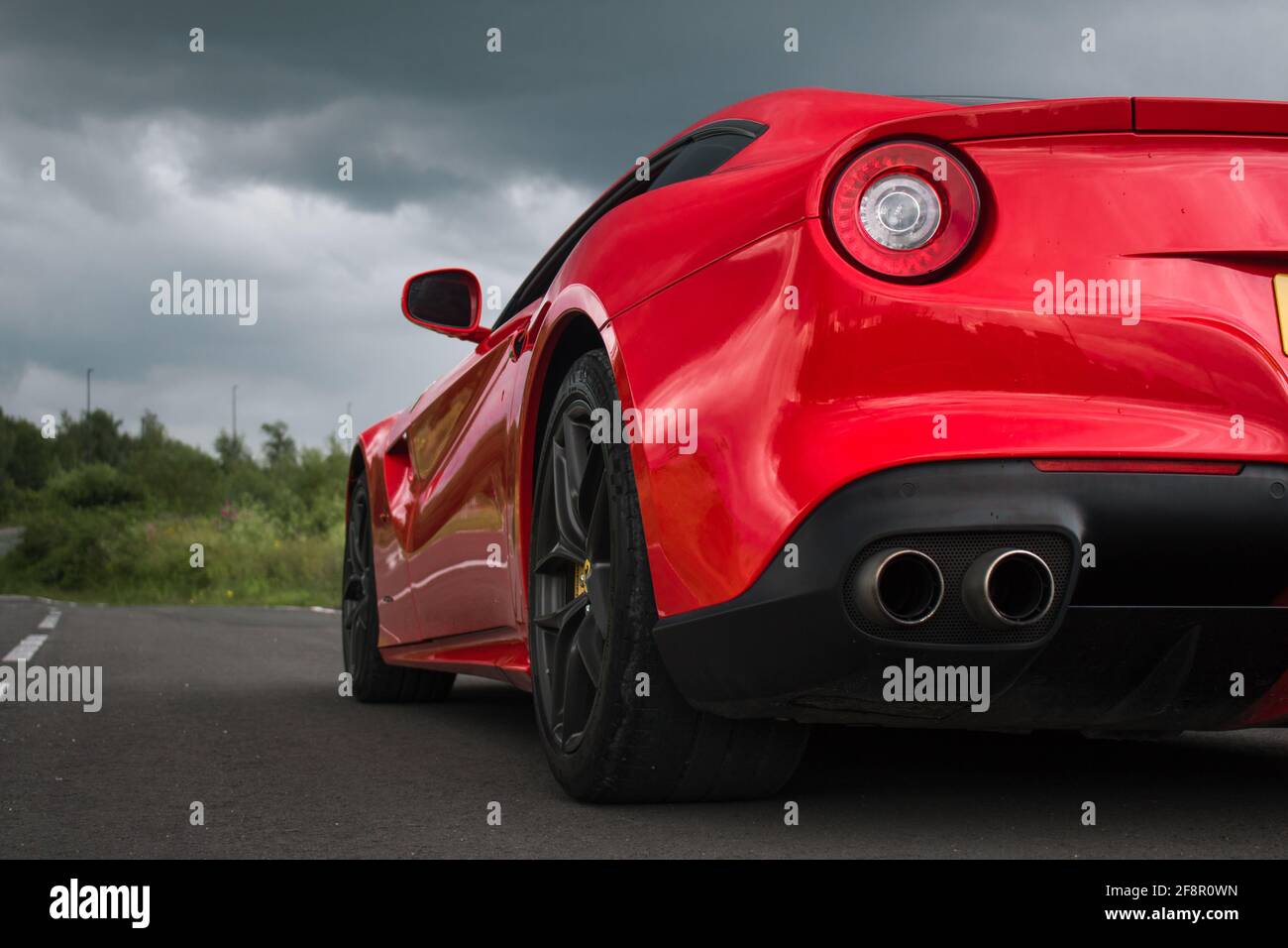 The Rear Of A Red 2013 Ferrari F12 Berlinetta With Gloss Front Wheels ...