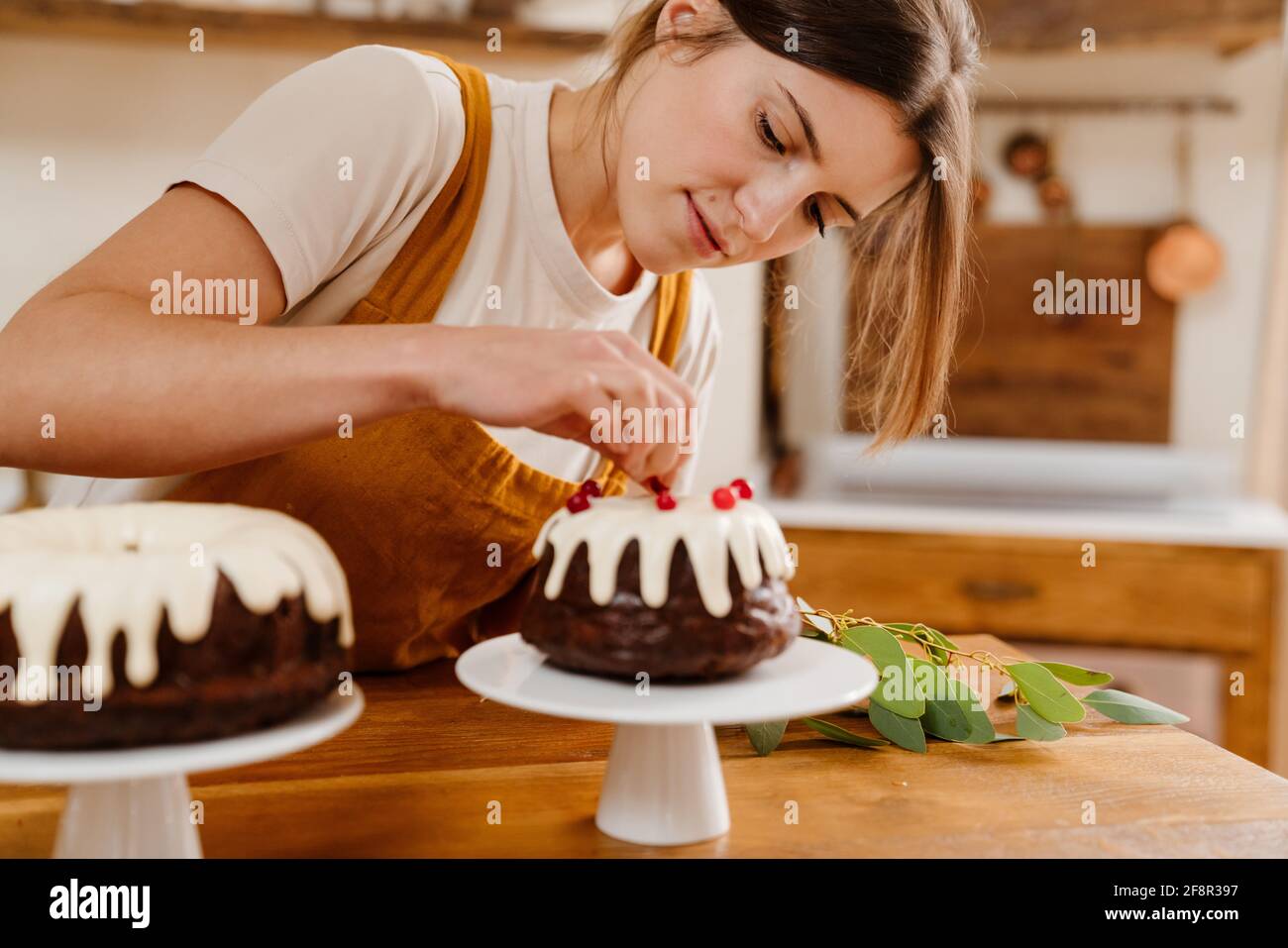 Caucasian focused pastry chef woman making chocolate cake at cozy ...