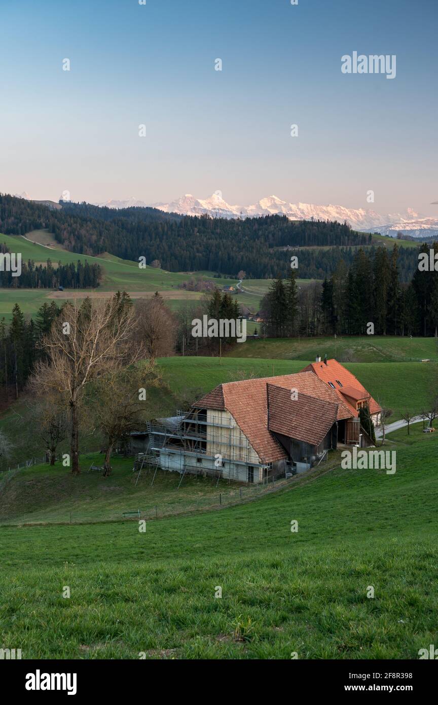 a traditional farm house in the hills of Emmental with Bernese Alps as ...