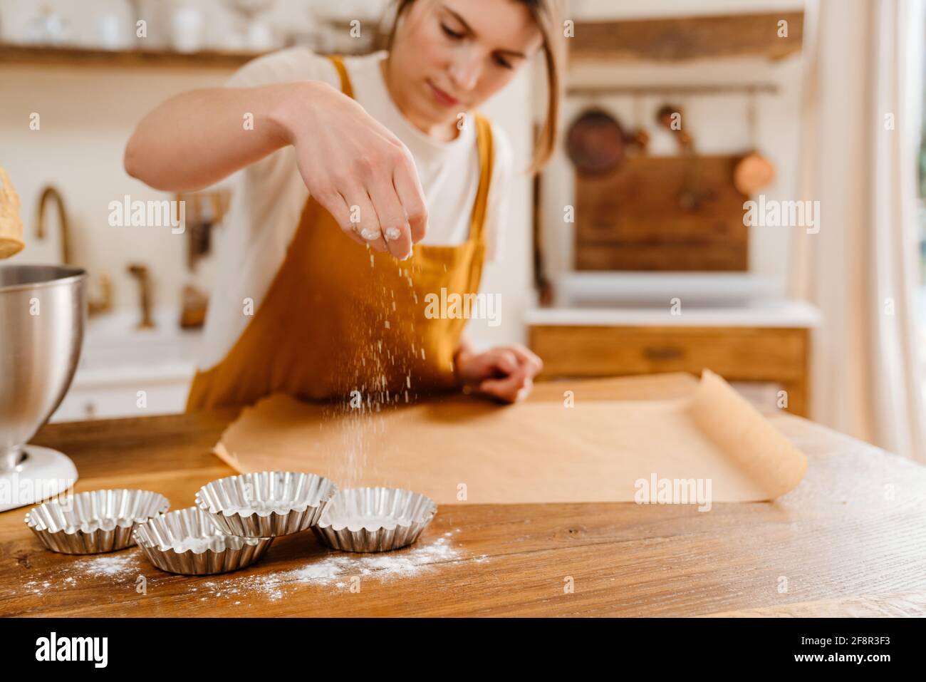 Beautiful focused pastry chef woman making tarts at cozy kitchen Stock ...